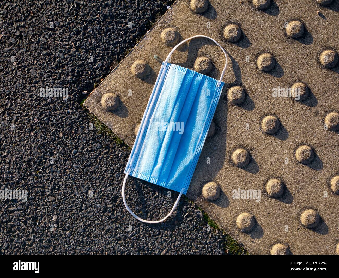 A used, blue surgical face mask used for COVID-19 PPE protection ...