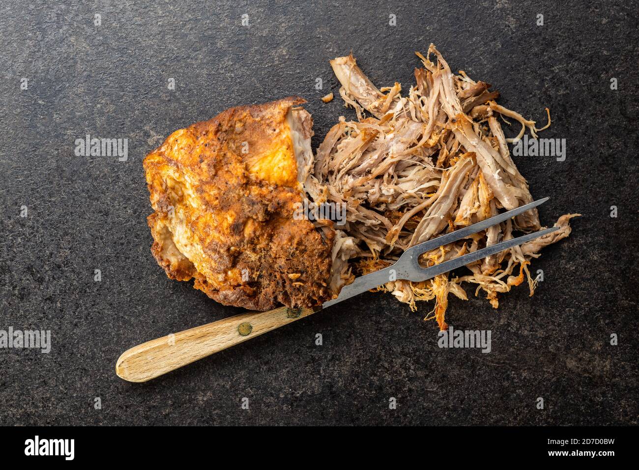 Pulled pork meat with fork on black table. Top view Stock Photo - Alamy