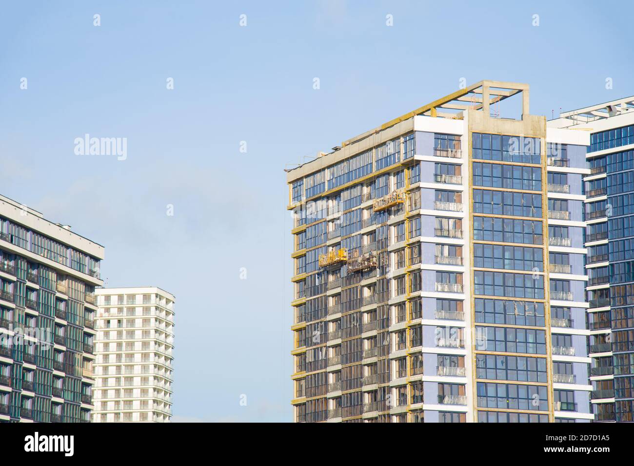 Suspended cradle on the facade of the skyscraper. Mobile scaffolding ...