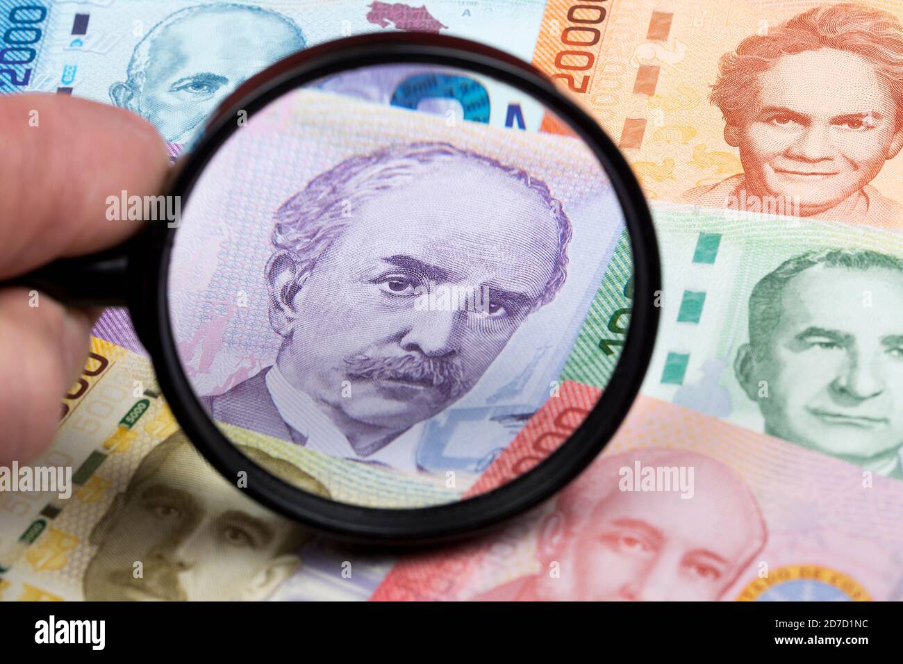 Costa Rican colon in a magnifying glass Stock Photo - Alamy