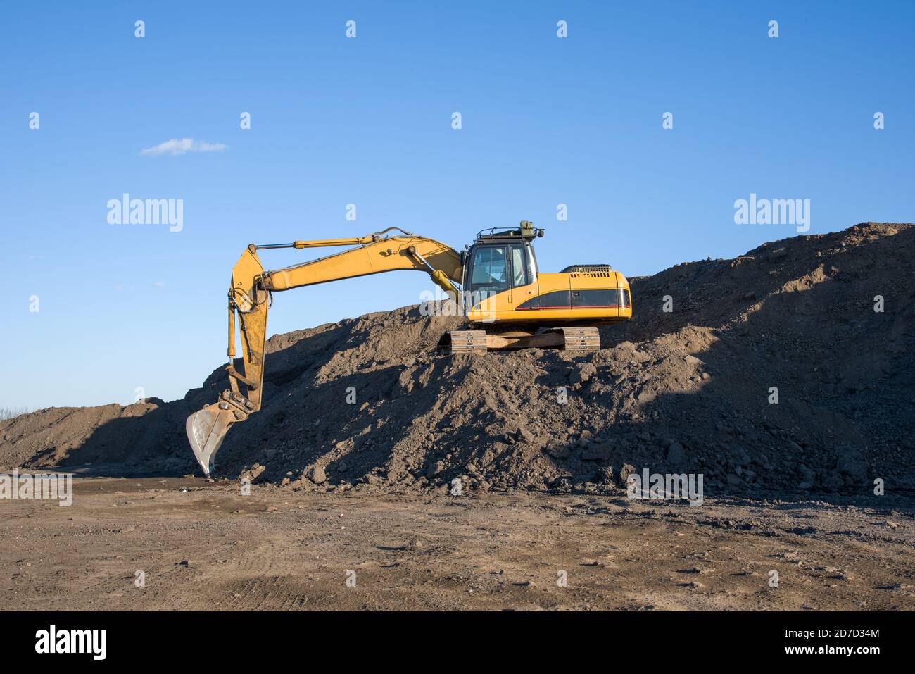 Excavator working at construction site. Backhoe digs ground in sand ...