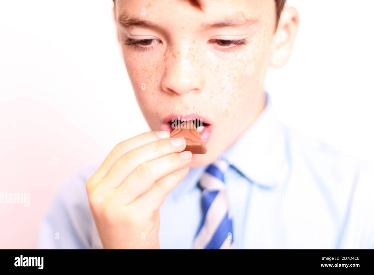 Child eating Quality Street Green Triangle chocolate sweet, close up ...
