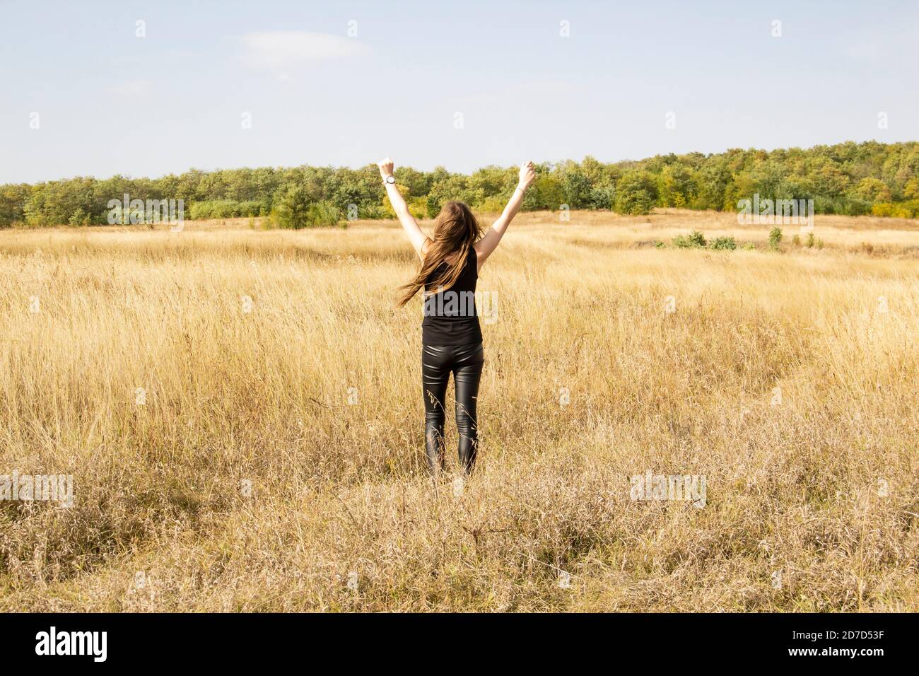 Beautiful young dark haired woman in black clothes stand in field ...