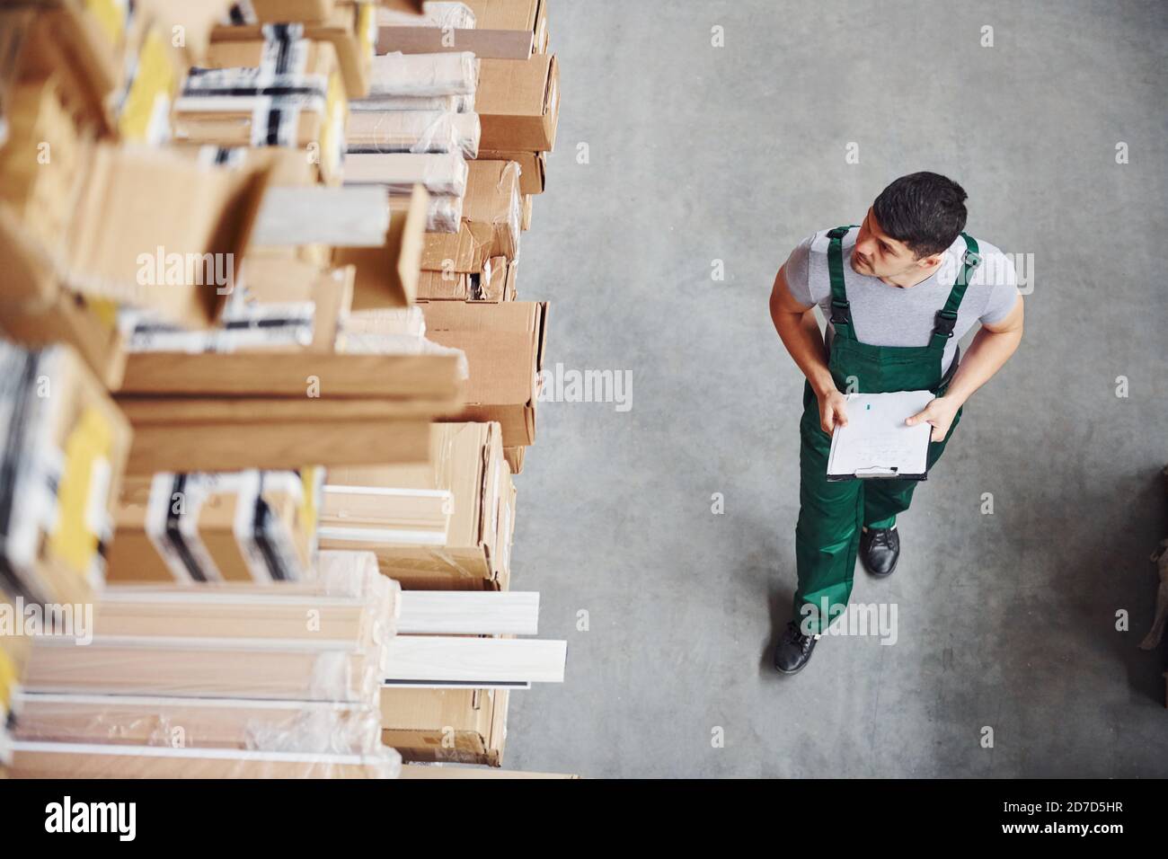Top view of male worker in warehouse with notepad in hands Stock Photo ...