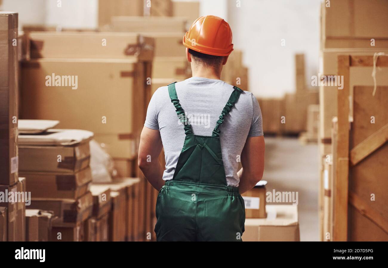 Young male worker in uniform is in the warehouse with pallet truck ...