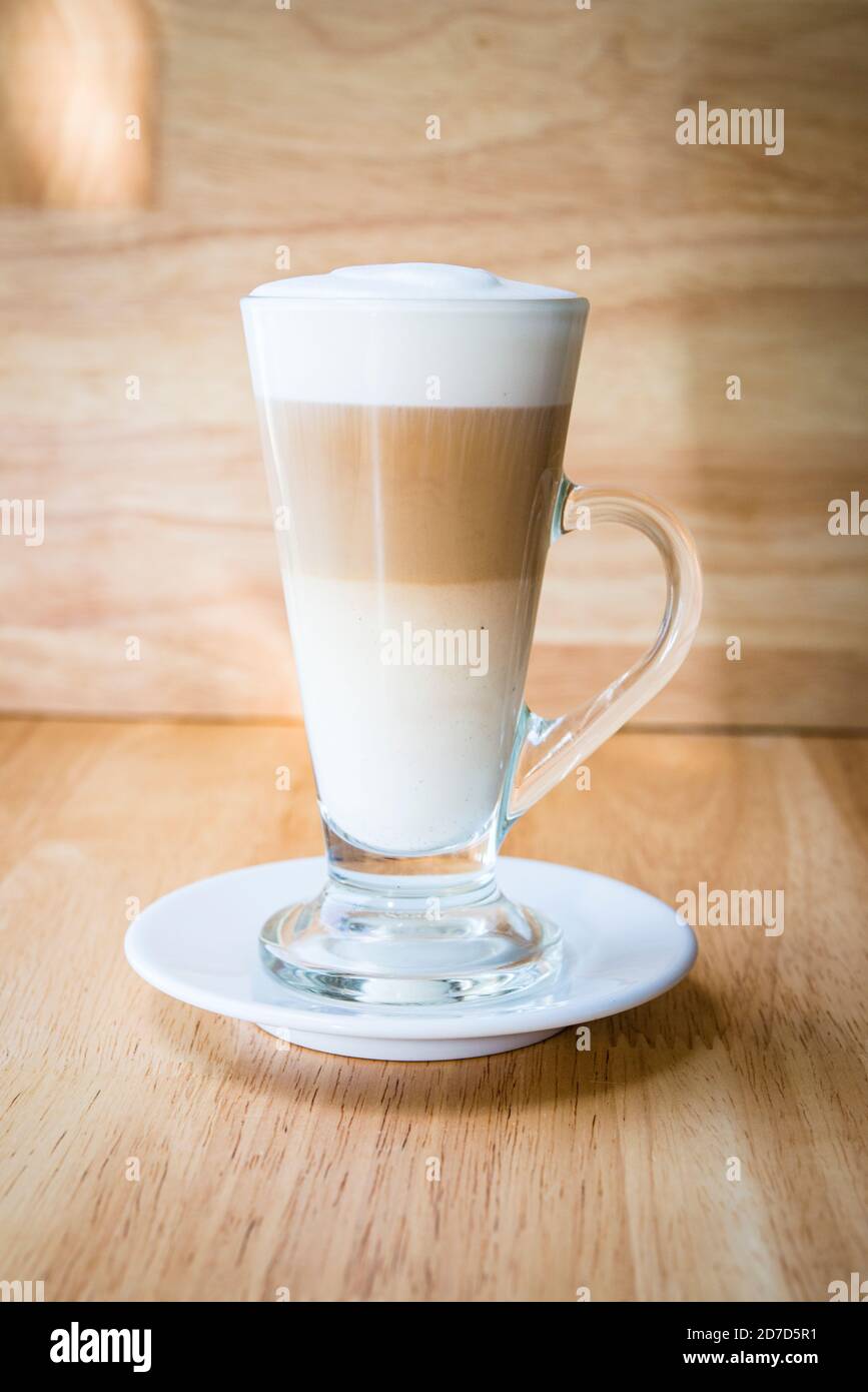 one latte coffee served in a clear glass with wood background Stock ...