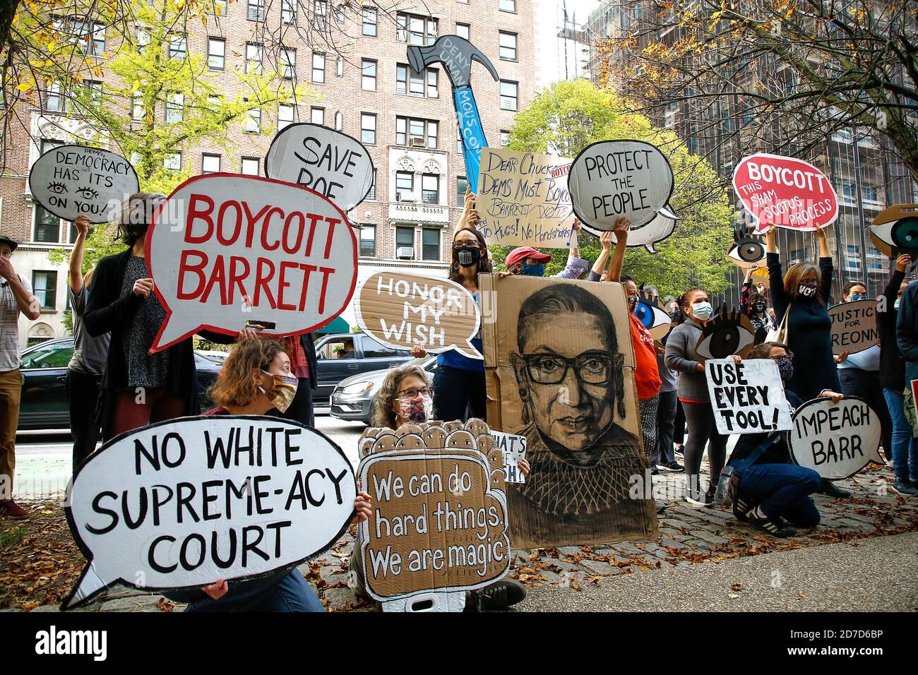 Protesters hold placards in front of Senator Chuck Schumer during the ...