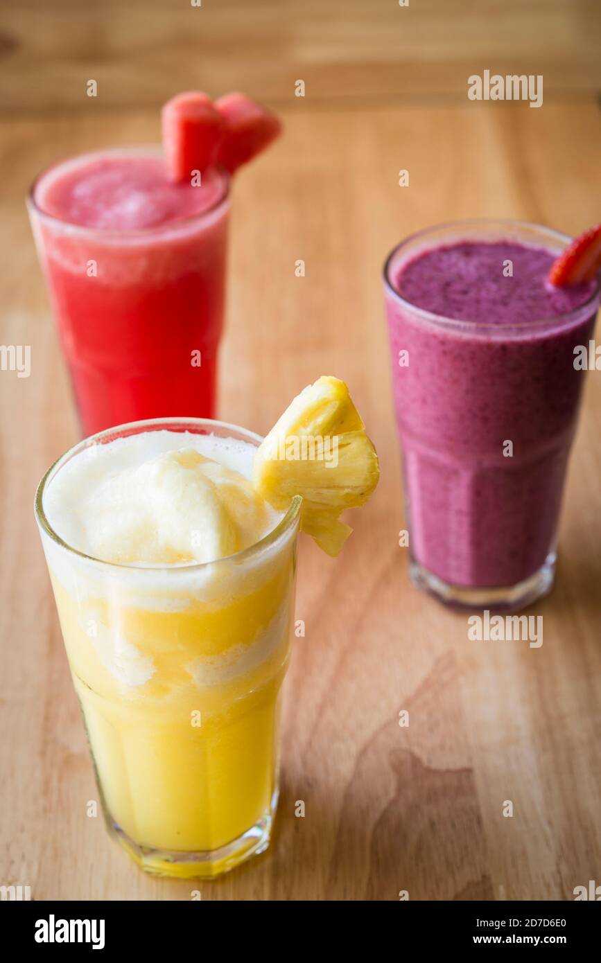 three different Fruit shakes, watermelon,pinapple and mixed berry on a ...