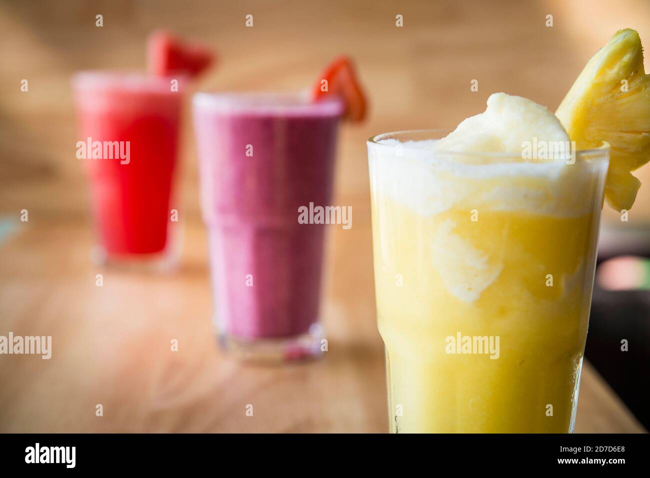 three different Fruit shakes, watermelon,pinapple and mixed berry on a ...