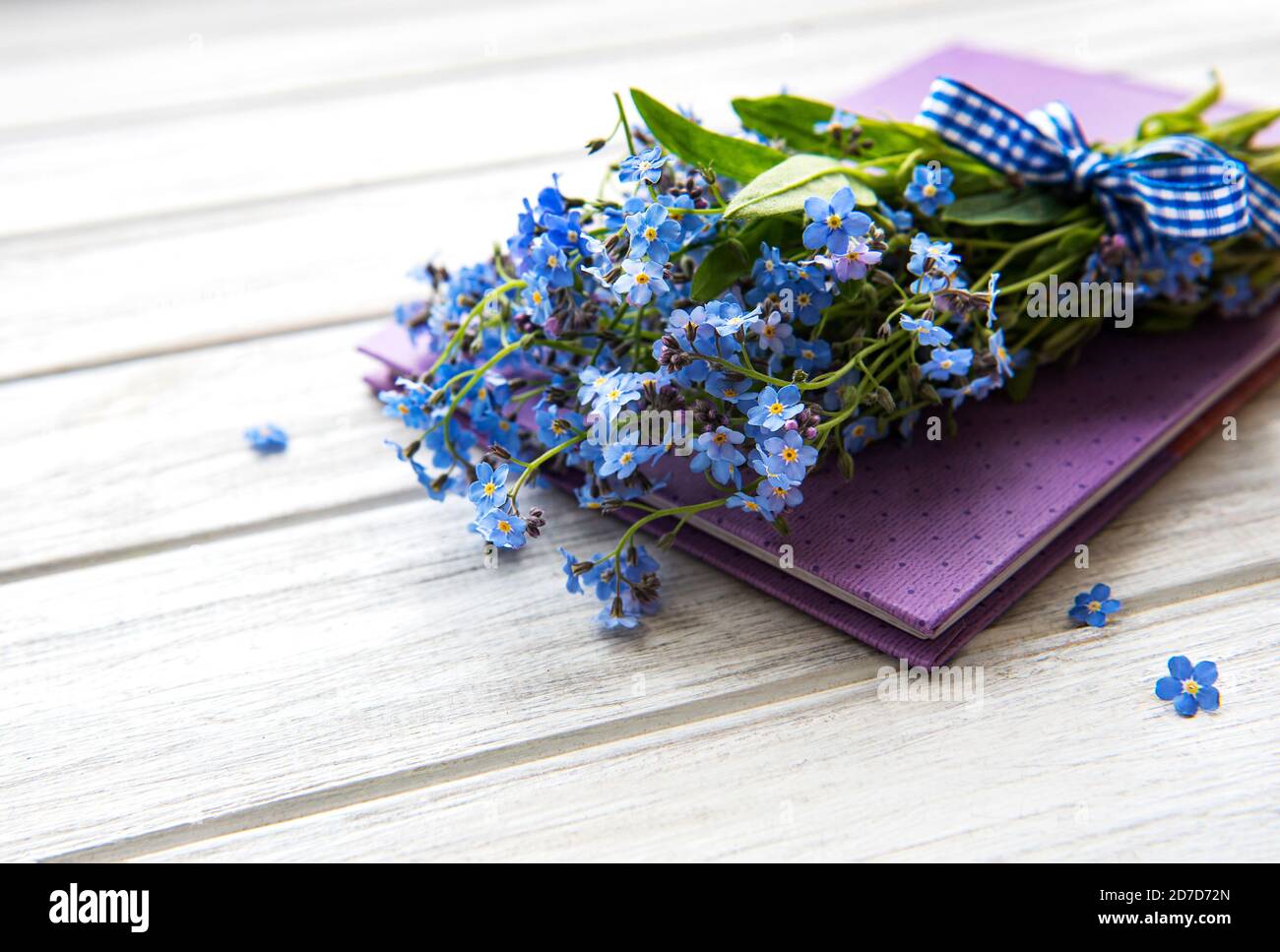 Forget me not flowers and notebook on white wooden background Stock ...