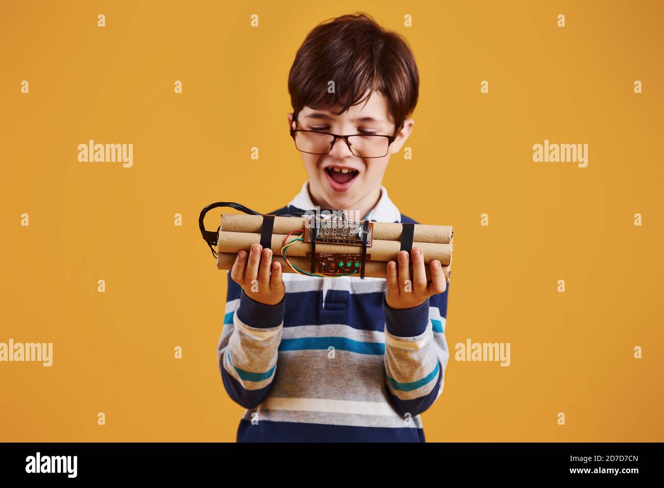 Little boy with explosive in the studio against yellow background Stock ...