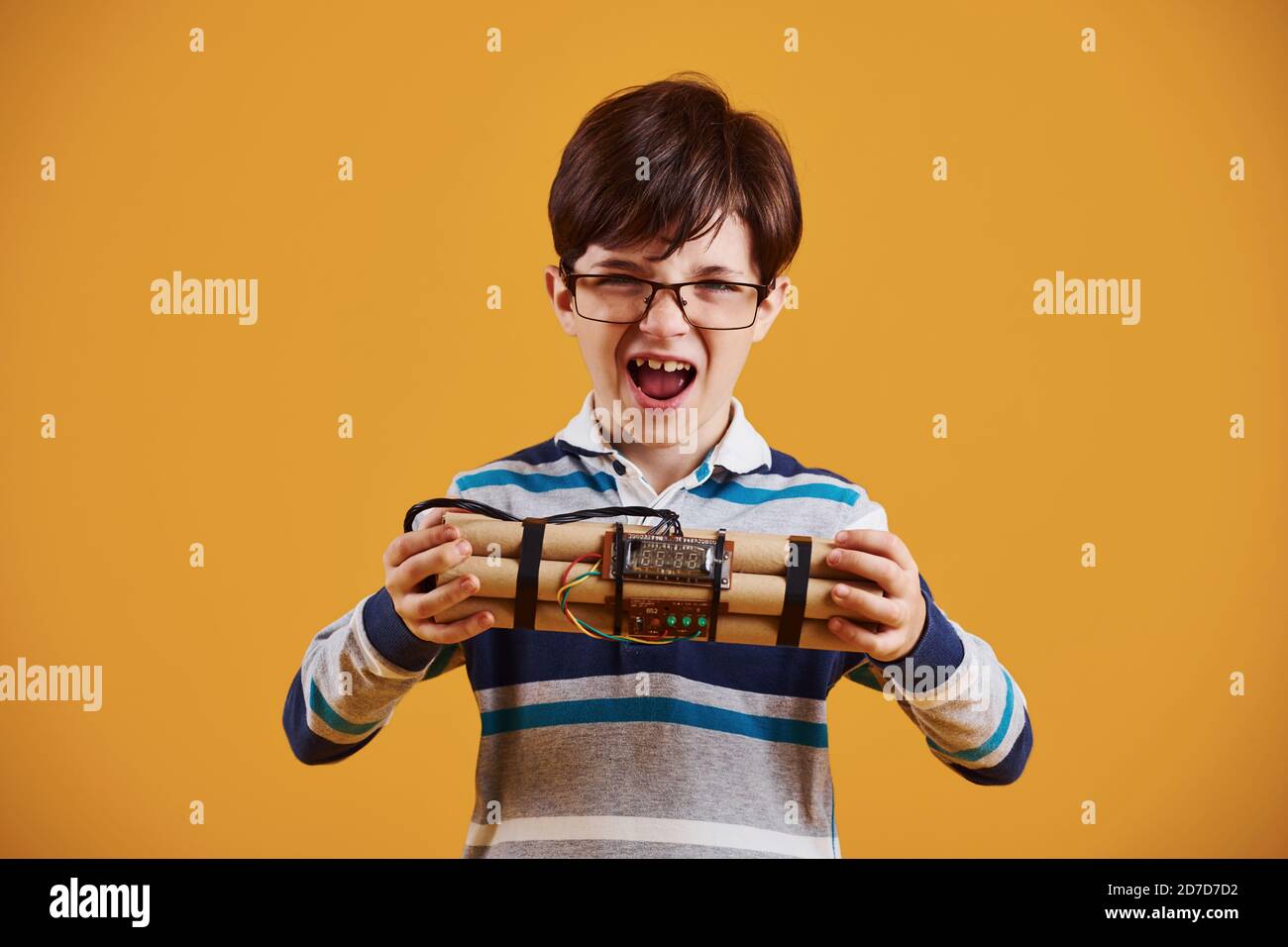 Little boy with explosive in the studio against yellow background Stock ...