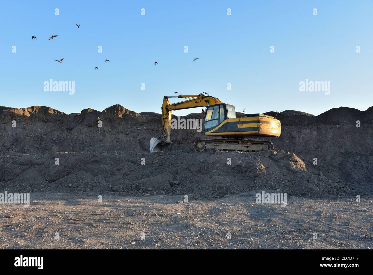 Excavator working at open pit mining. Backhoe digs gravel in sand ...
