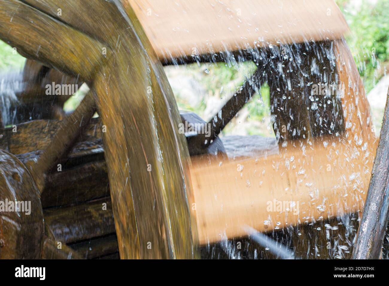 Decorative water mill wheel and splashes of water. Wooden water mill ...