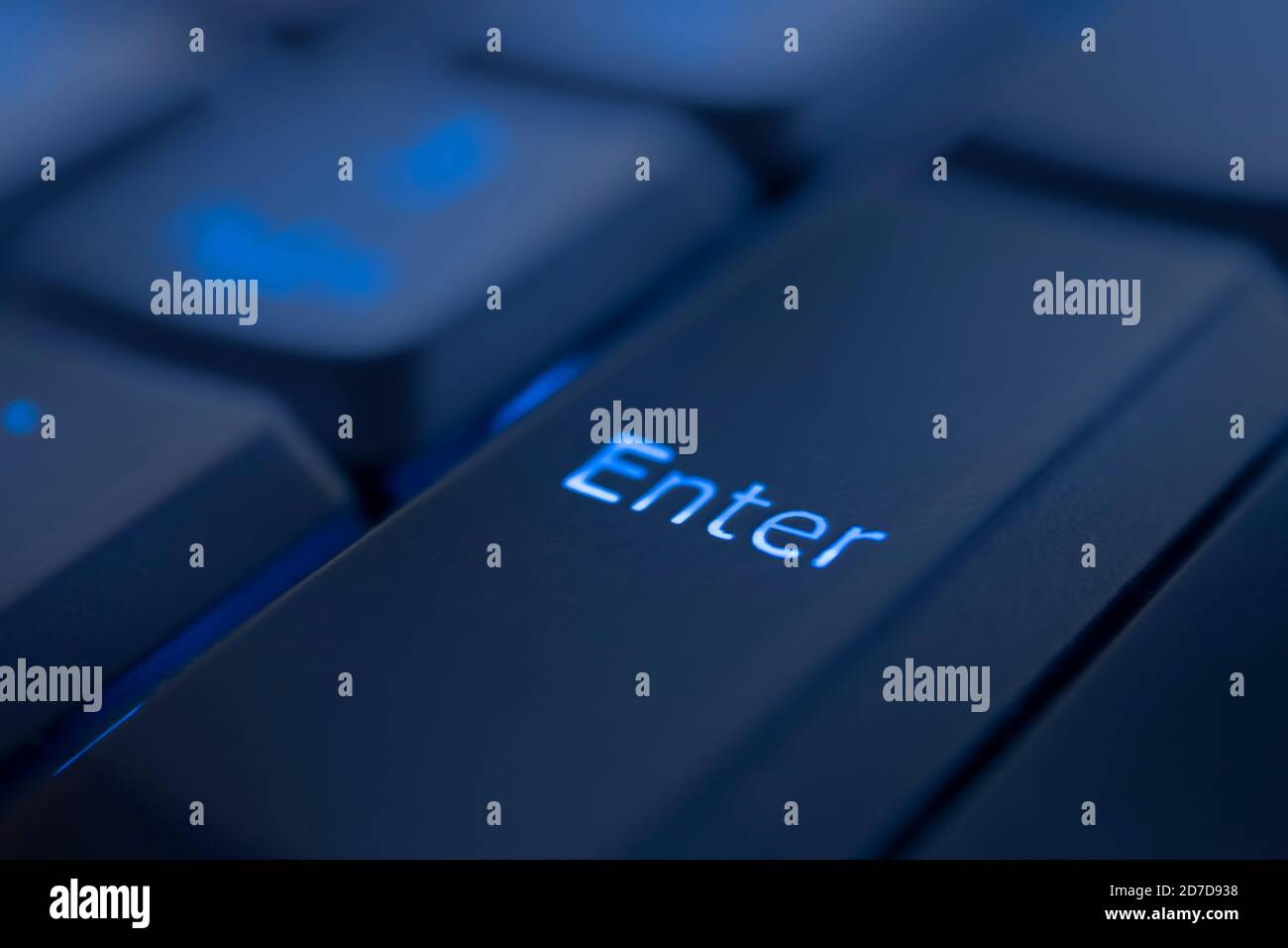 Enter key illuminated by blue LED light. Close-up of computer keyboard ...