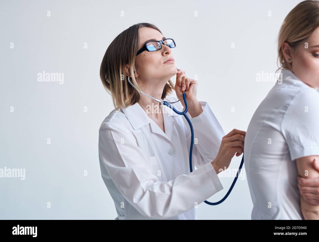 Professional doctor woman with stethoscope and female patient side view ...