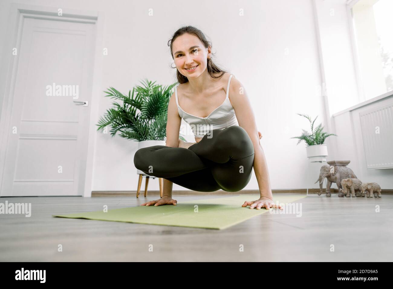 Full length of beautiful young sporty woman working out in yoga studio ...