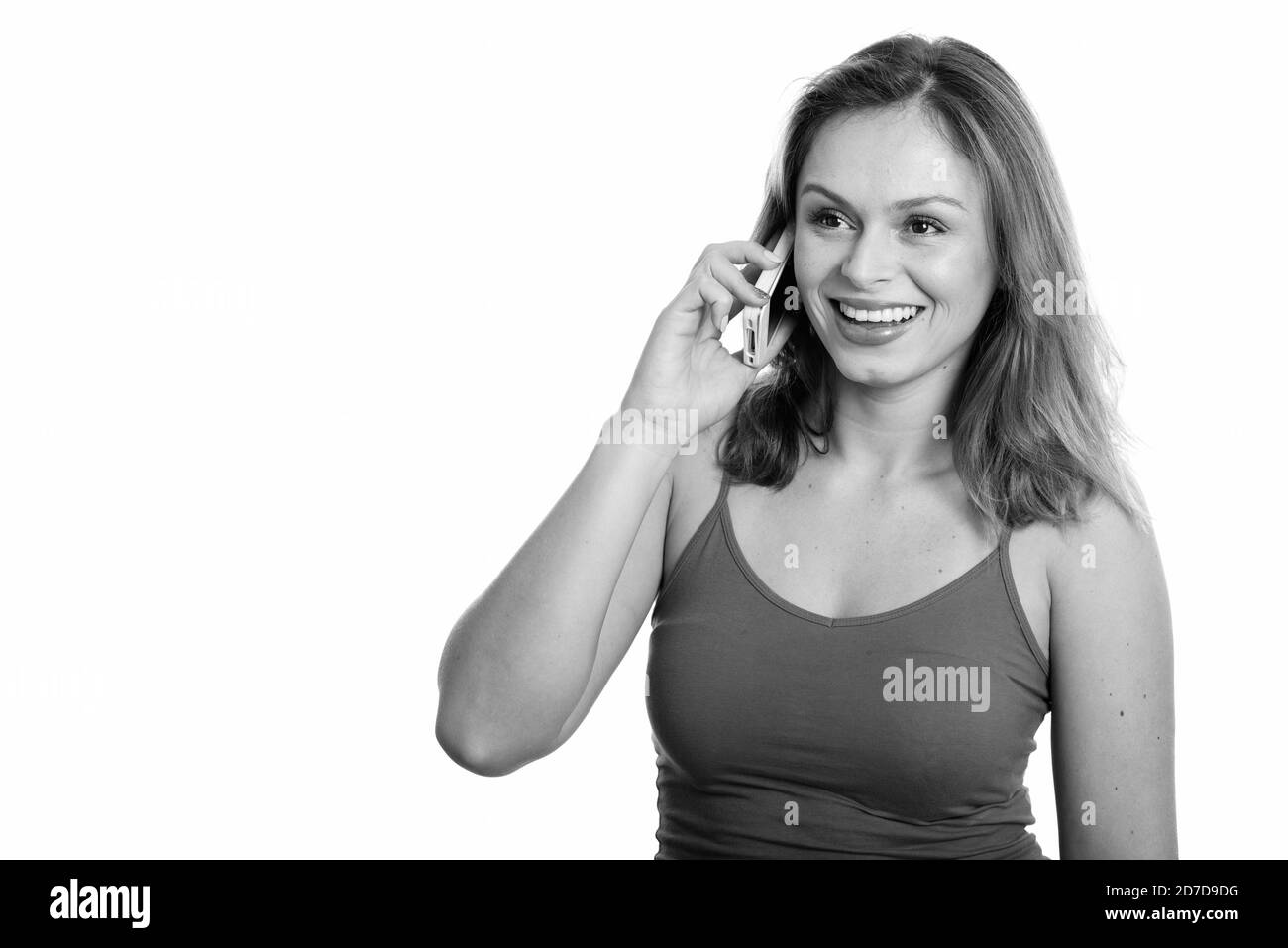 Young happy Brazilian woman smiling while talking on mobile phone and ...