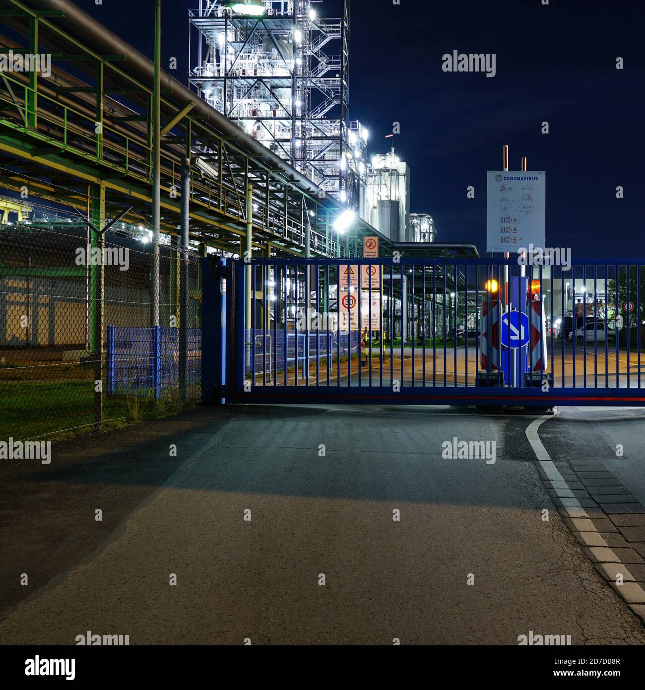 Metal construction with lights behind a gate at night Stock Photo - Alamy