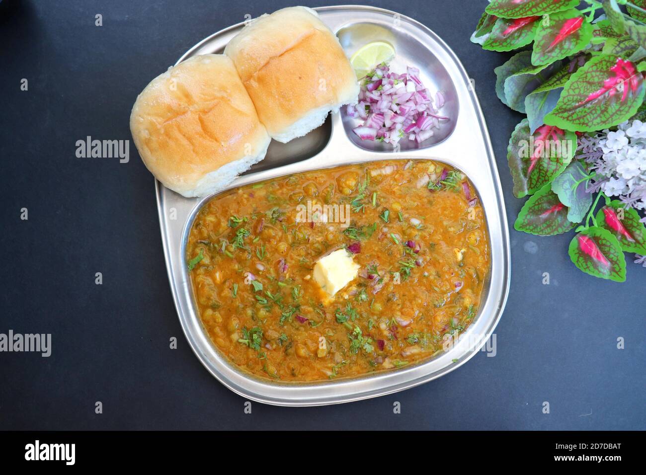 Indian Mumbai Street style Pav Bhaji, garnished with peas, raw onions ...