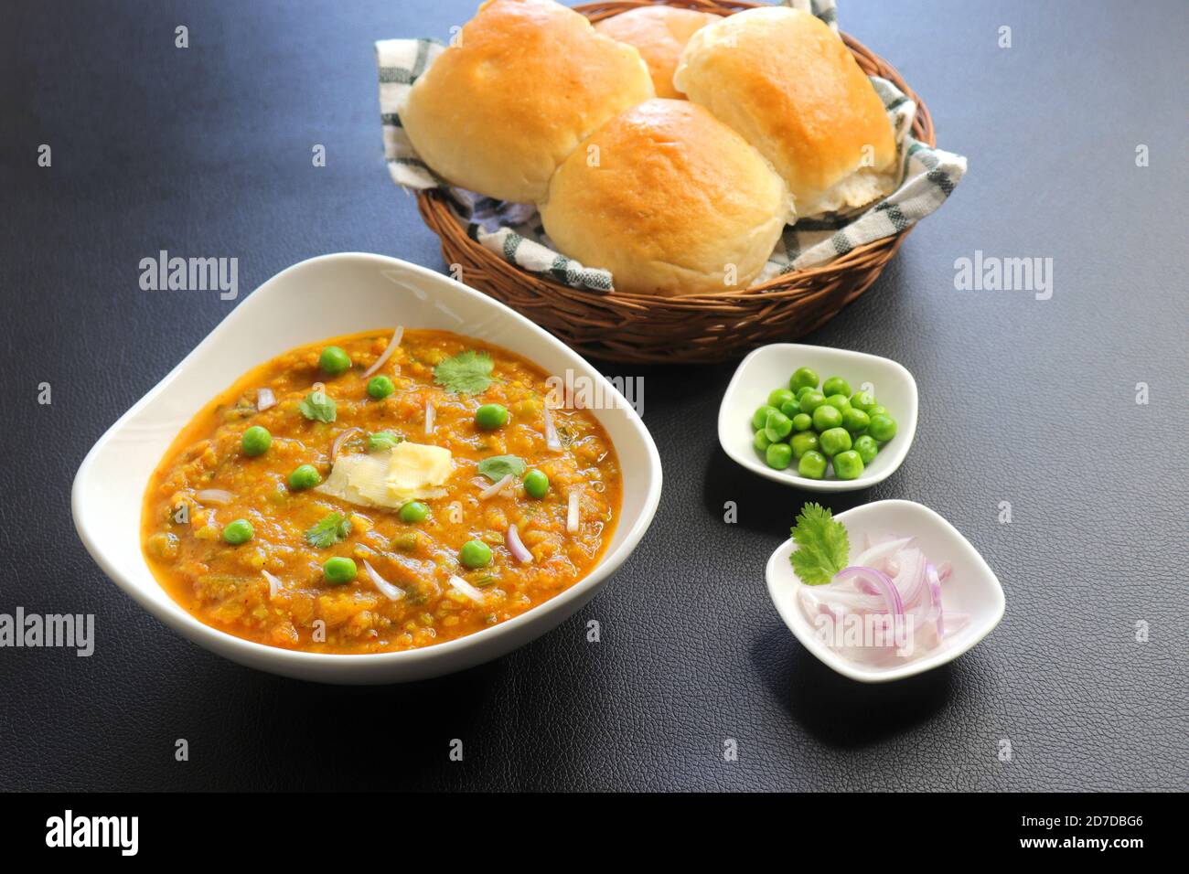 Indian Mumbai Street style Pav Bhaji, garnished with peas, raw onions ...