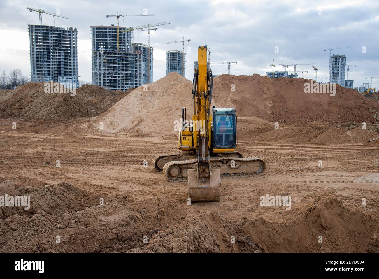Excavator during earthmoving at construction site. Backhoe dig ground ...