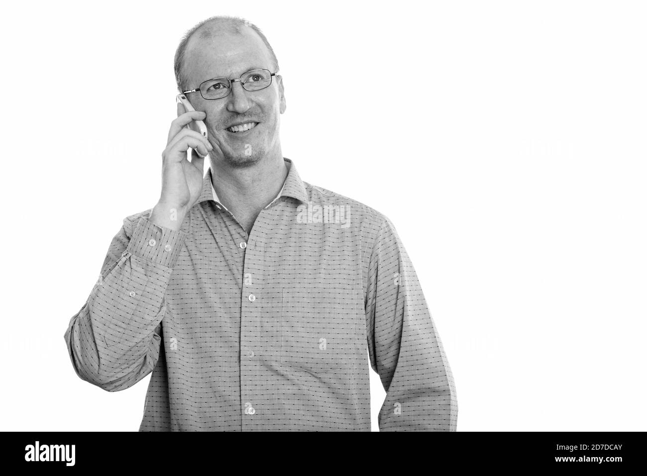 Thoughtful happy businessman smiling while talking on mobile phone ...