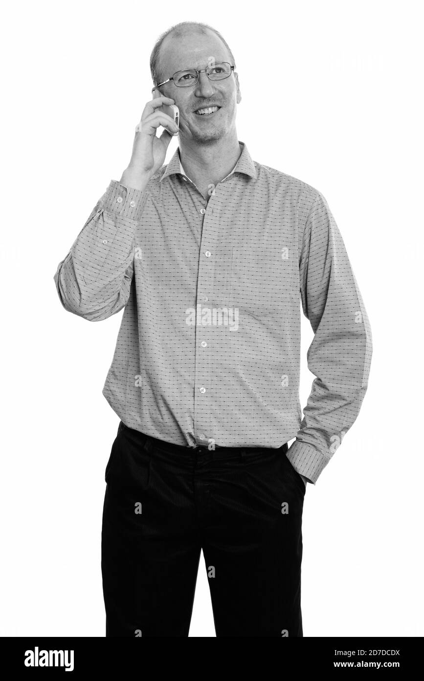 Happy businessman smiling while talking on mobile phone and thinking ...