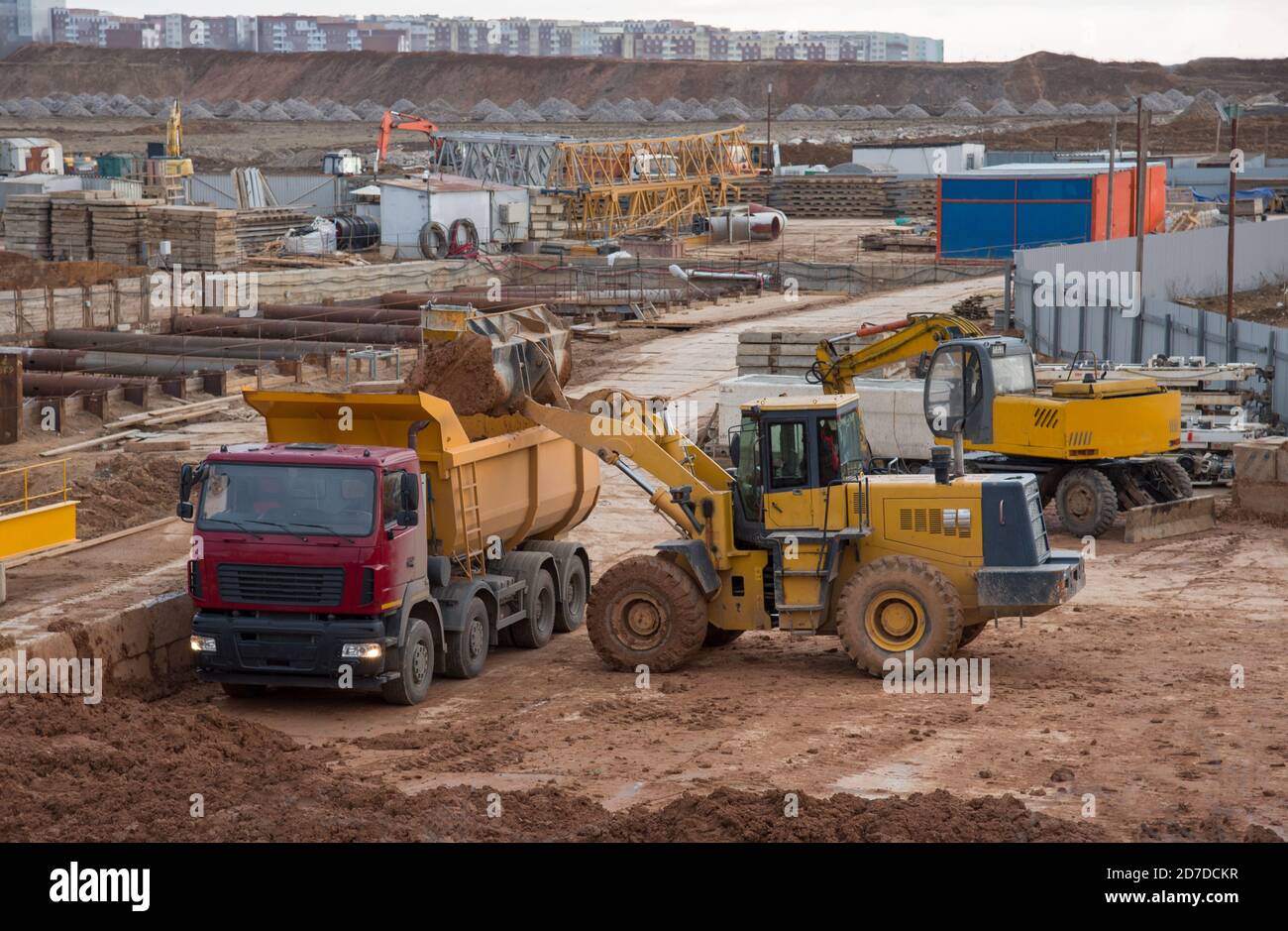 Wheel front-end loader loading sand into dump truck at the construction ...