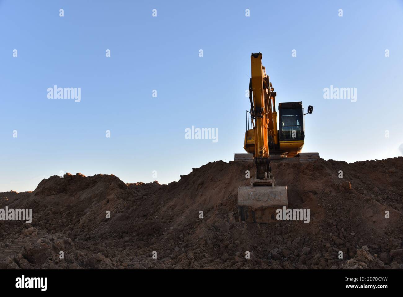 Excavator working at construction site. Backhoe digs ground in sand ...