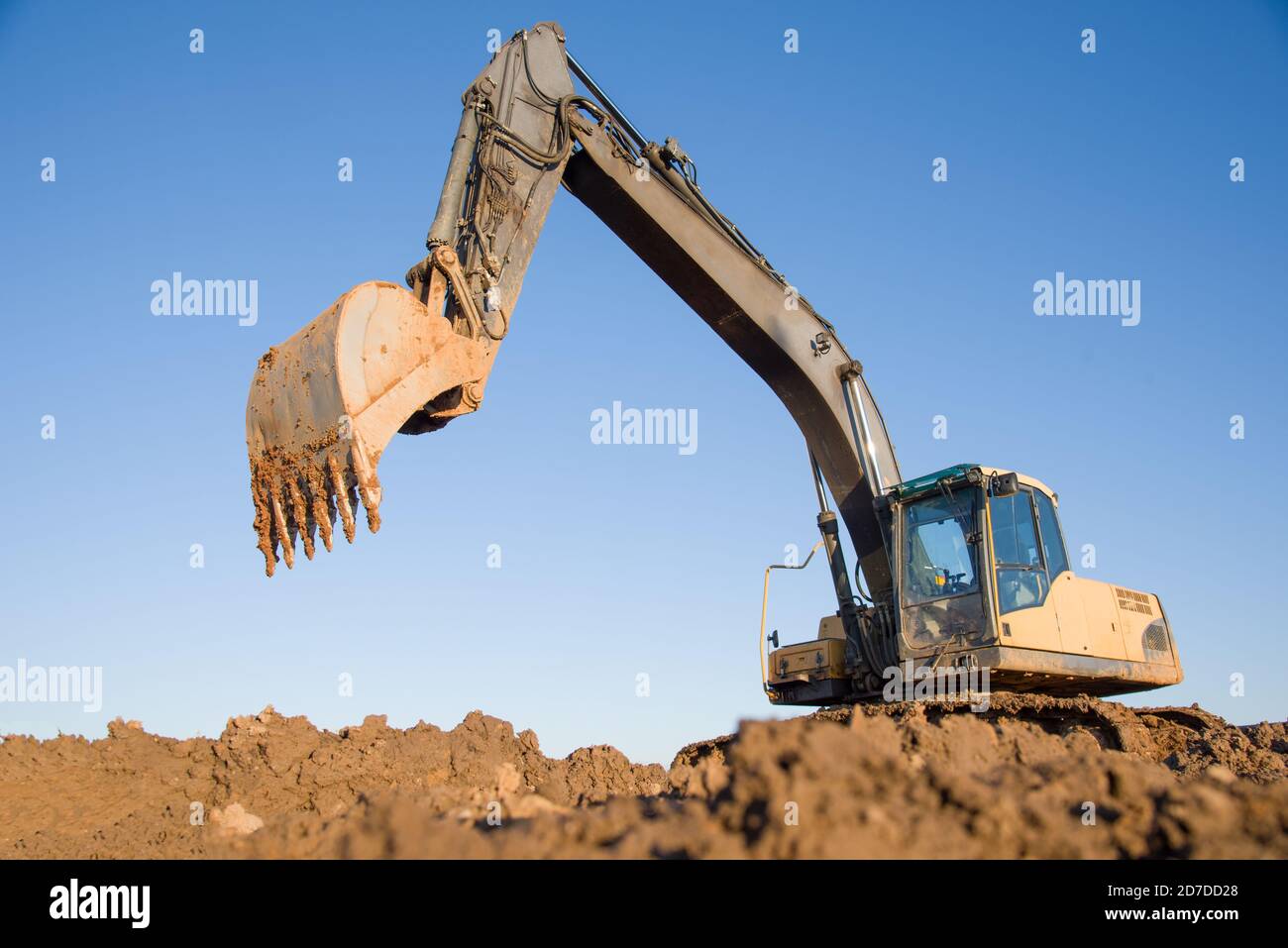 Excavator working at construction site. Backhoe digs ground in sand ...