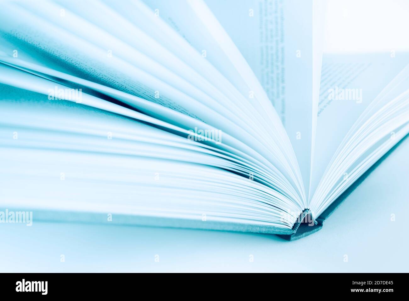 Shallow depth of field in open book in blue color. Defocused pages ...