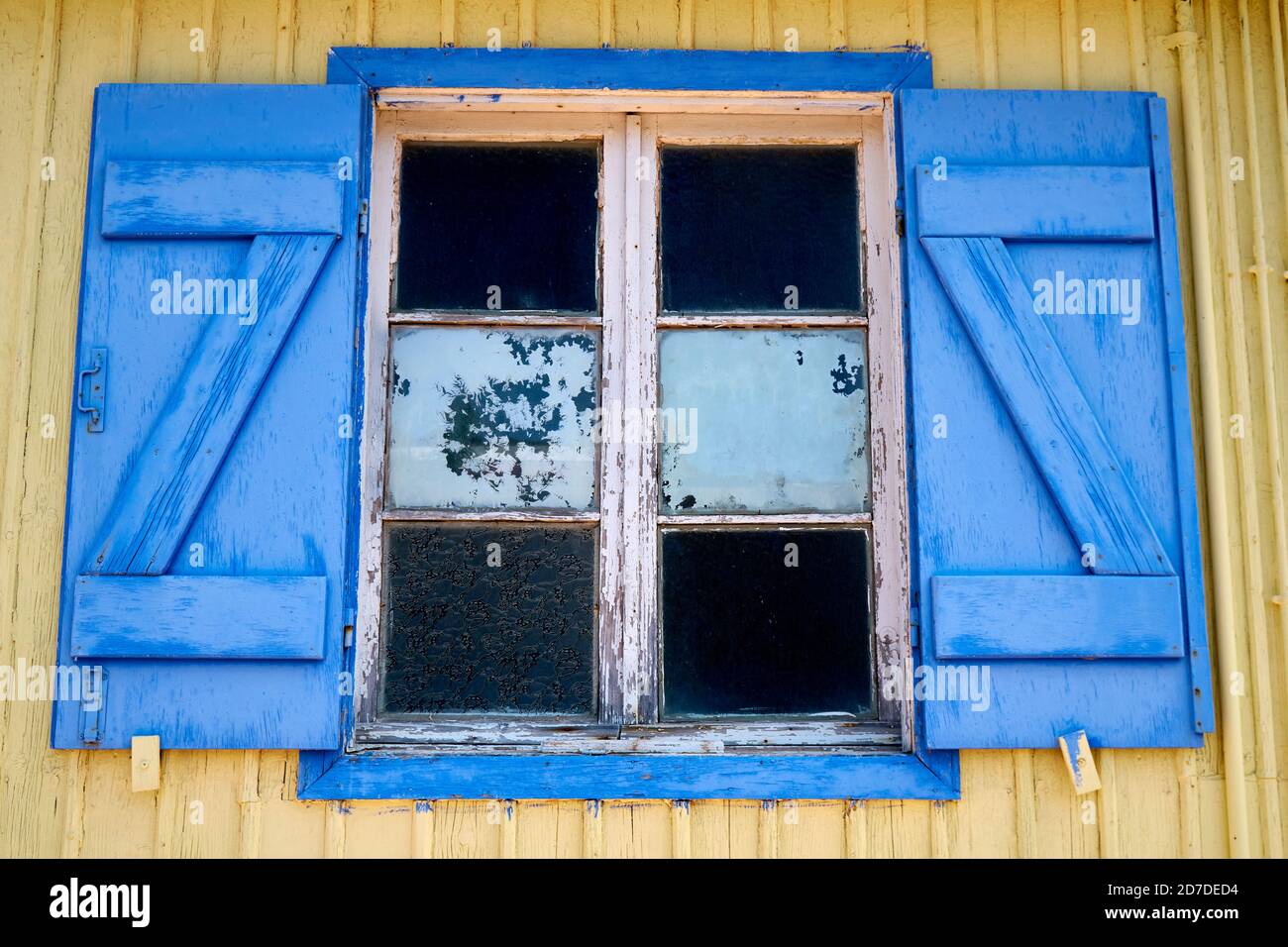 old blue window with open coverings on yellow wall Stock Photo - Alamy