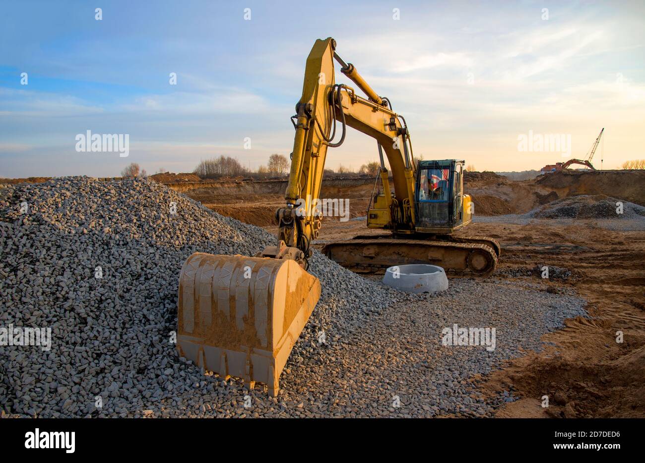Excavator during earthmoving work at open-pit mining on blue sky ...