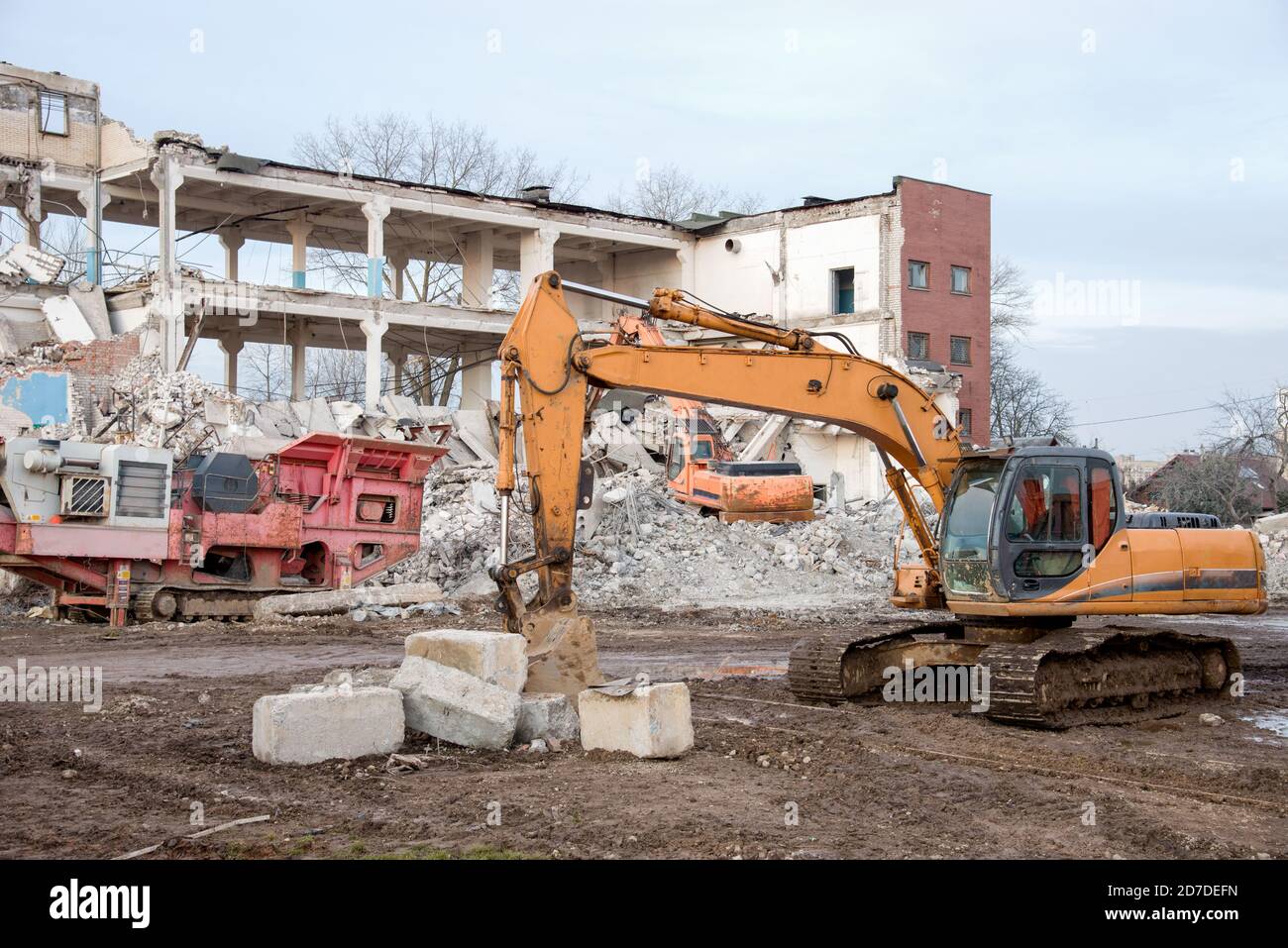 Yellow excavator with bucket at demolition of tall building. Hydraulic ...