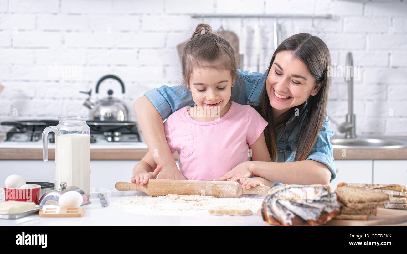 Happy family. Mom and daughter prepare pastries in the kitchen. The ...