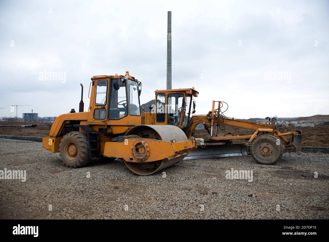 Motor Grader and Soil Compactor at a construction site level the ground ...