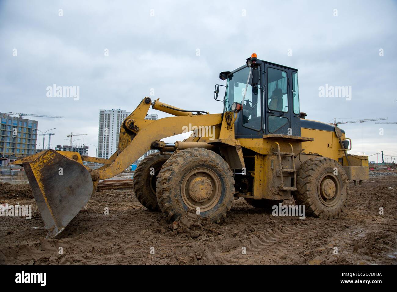 Front-end loader working at construction site. Earth-moving heavy ...