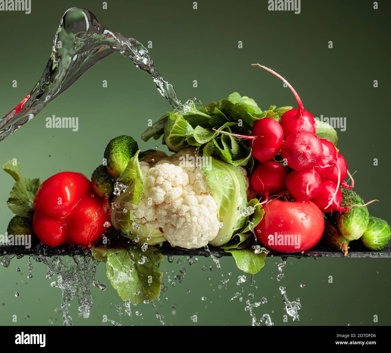 Various raw vegetables with water splash. Cauliflower, tomato, cucumber ...