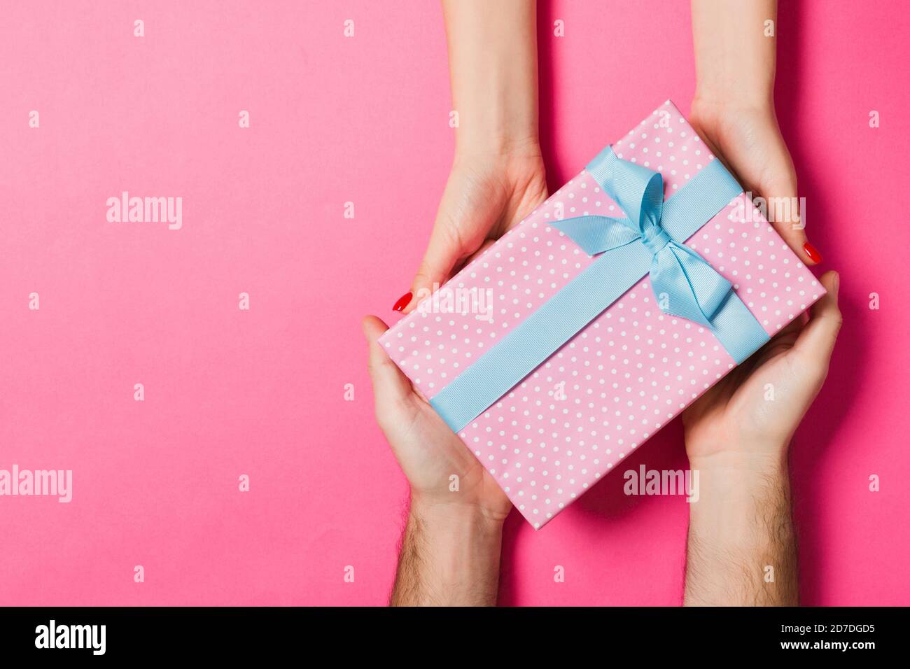 Top view of giving and receiving a gift on colorful background. Present ...