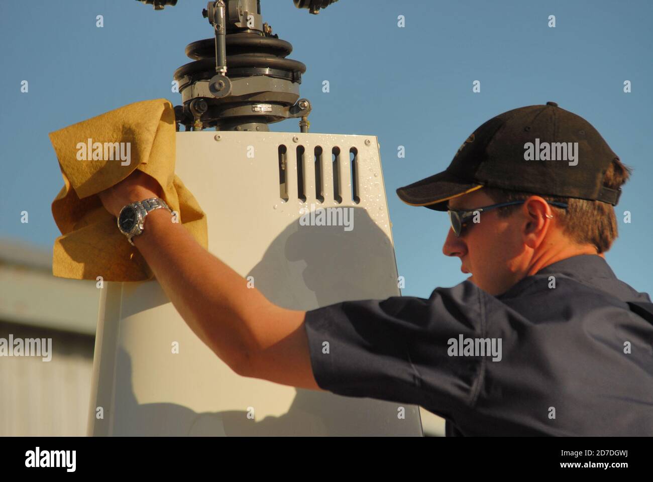 A pilot cleaning the rotor mast of a Robinson R22 Beta helicopter Stock ...