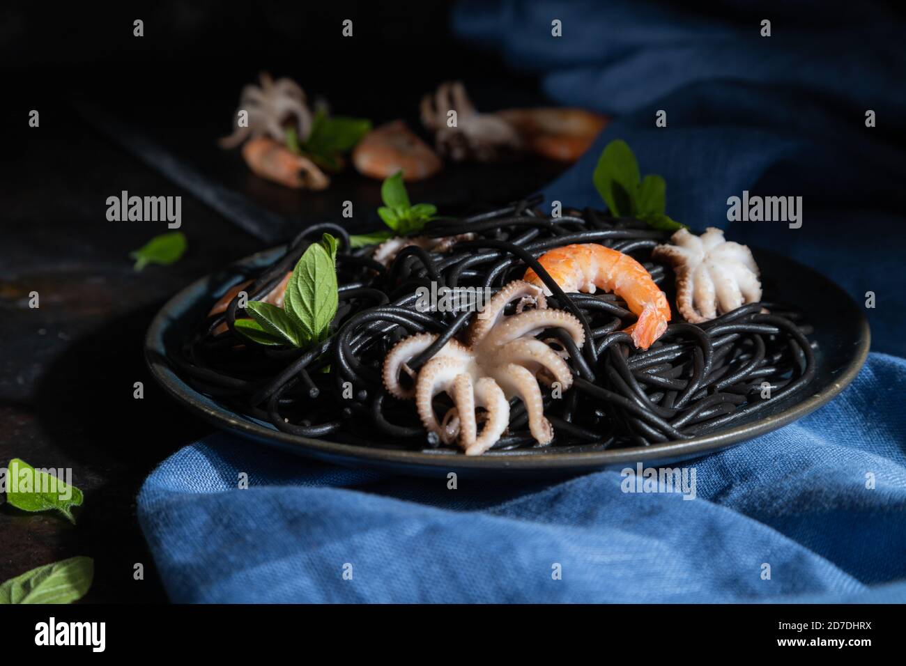 Black cuttlefish ink pasta with shrimps or prawns and small octopuses ...