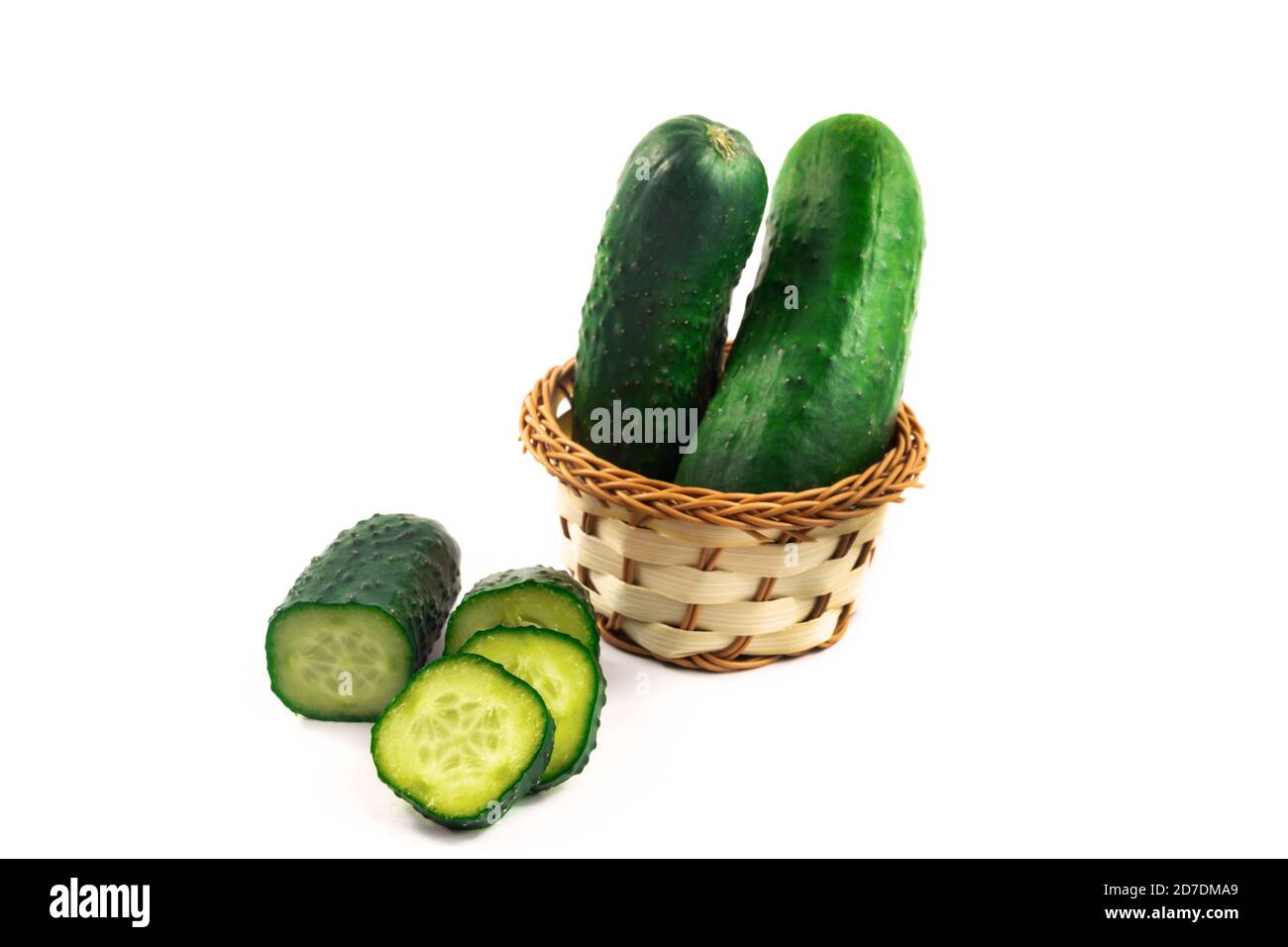 Harvesting cucumber and slices in a wicker miniature basket, for a ...