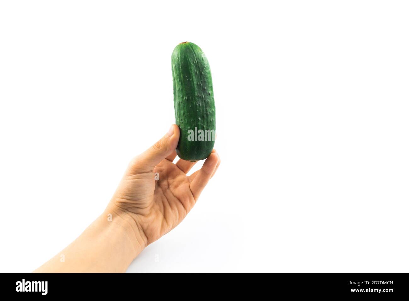 Illustrative photo of one cucumber vegetable in man's hand on white ...