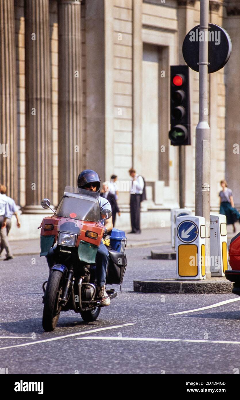 A motorcycle courier makes a left turn in heavy traffic at the Bank ...