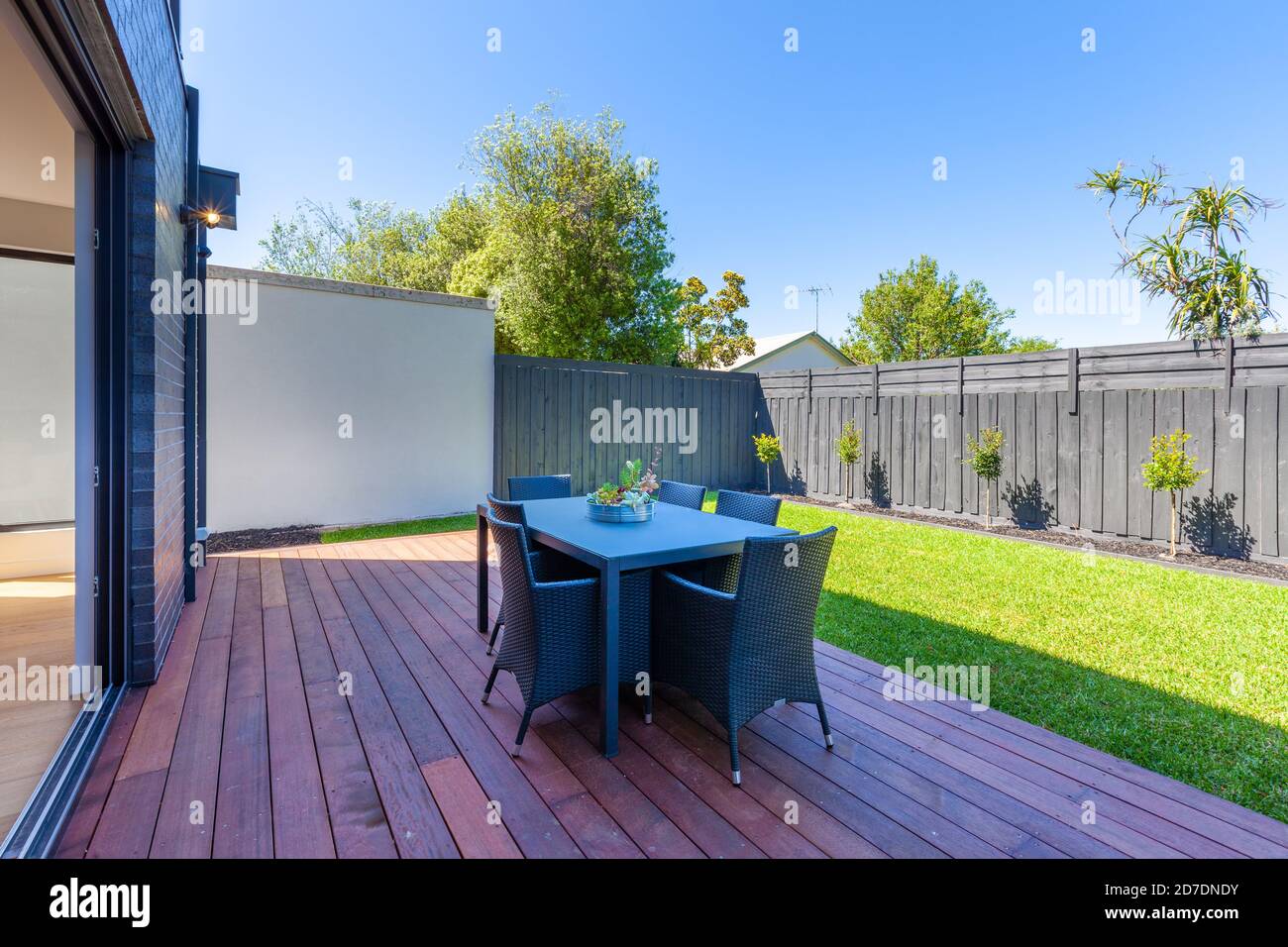 Outdoor dining table on wooden deck in a suburban home back yard in ...