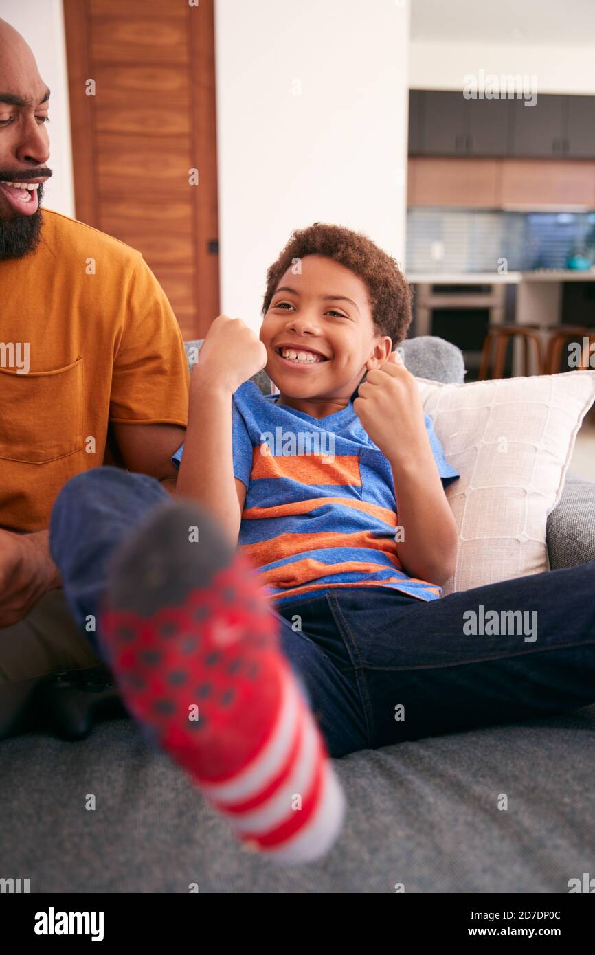 Loving African American Father And Son Sitting On Sofa At Home Together ...