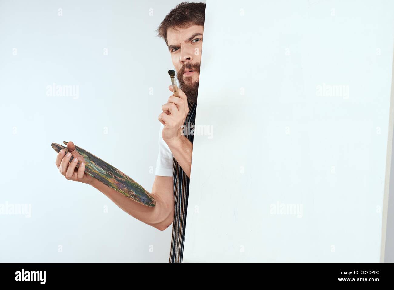 Male artist hiding behind an easel palette drawing art Stock Photo - Alamy