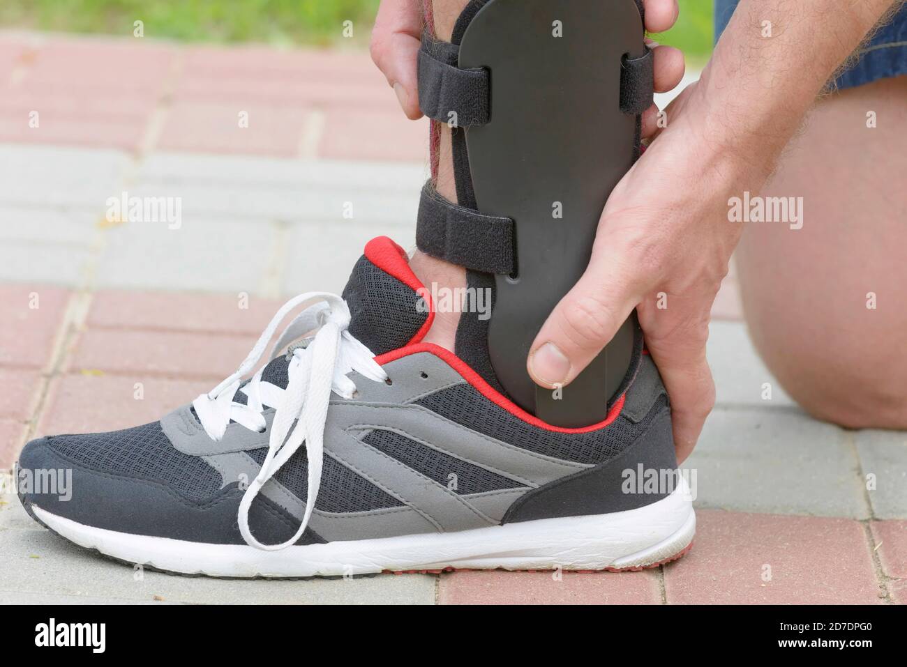 Man in athletic sneakers wearing ankle orthosis or brace Stock Photo ...