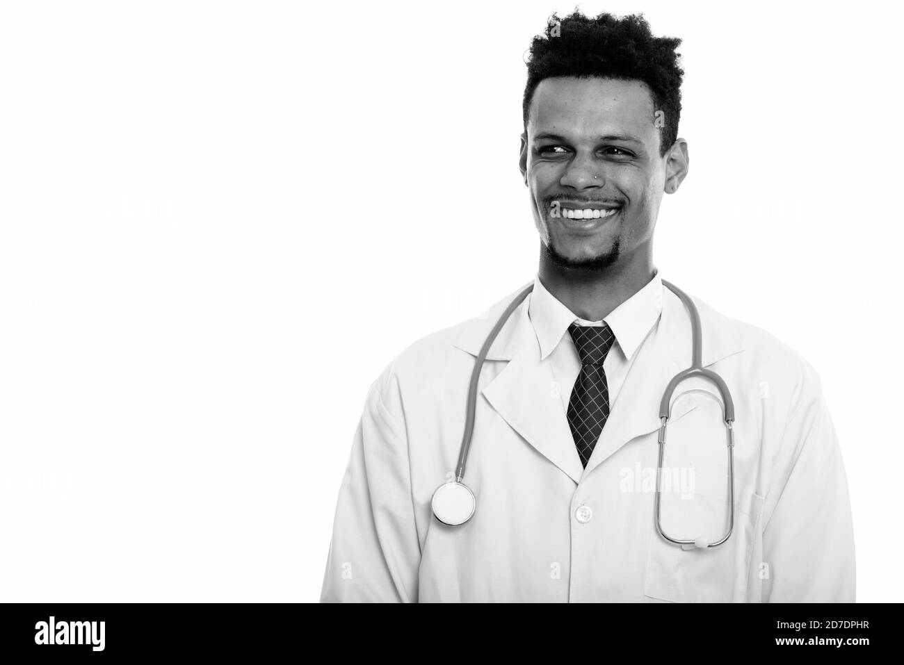 Young happy African man doctor smiling while thinking and looking at ...